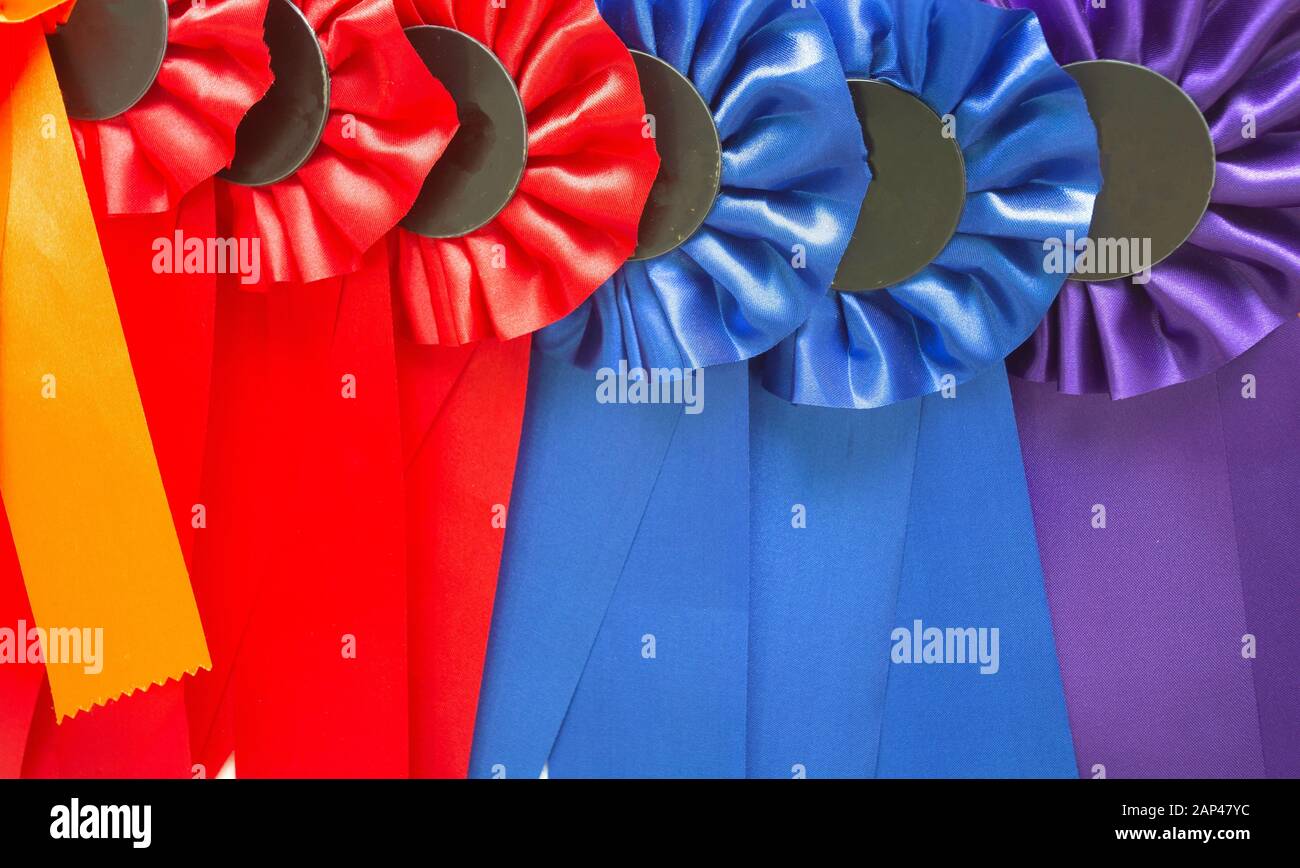 A lots of ribbons rosettes medals overlapping in a row background ...