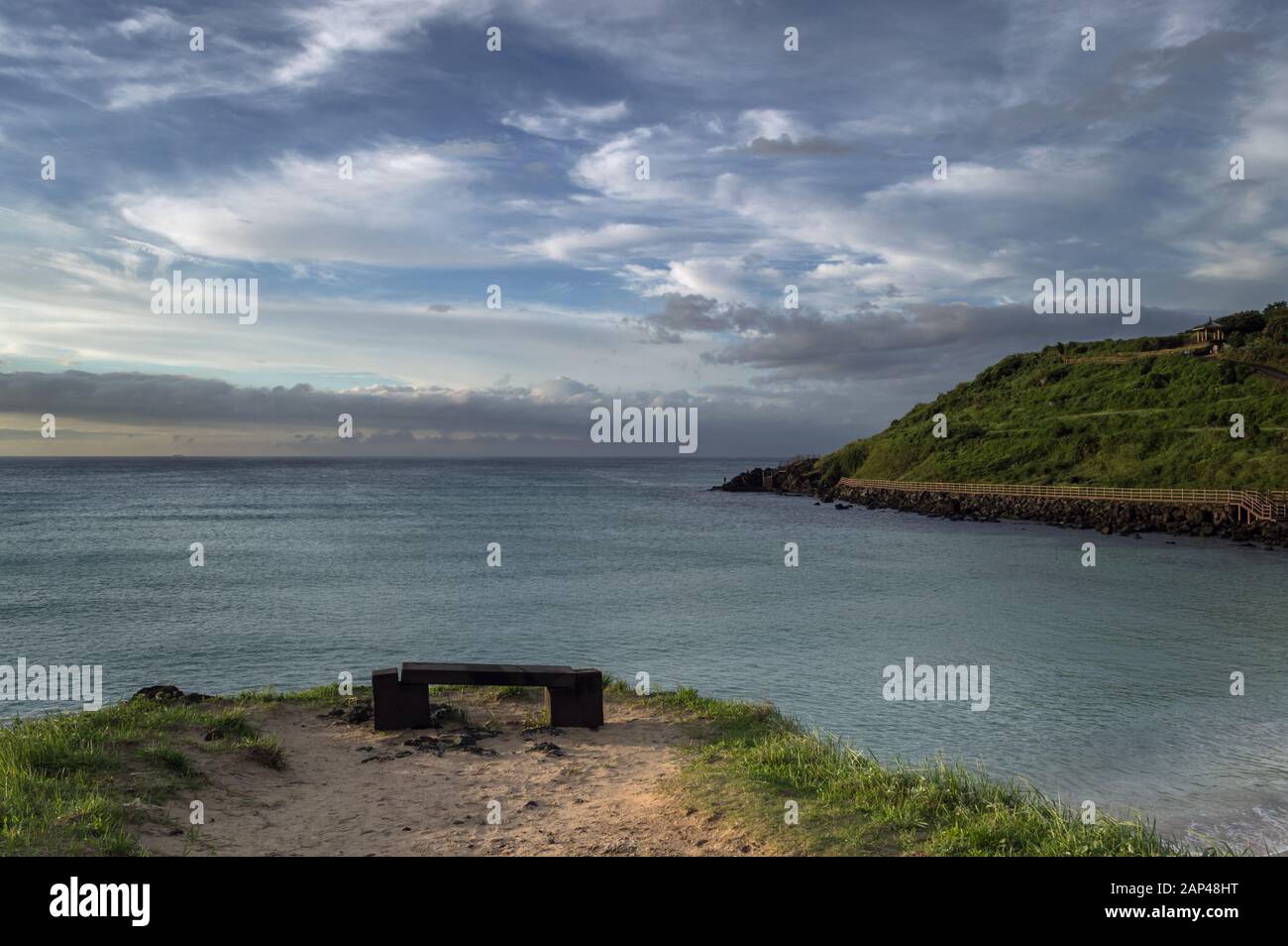 empty lava rock bench with vast sea and scenic skies on backround at ...