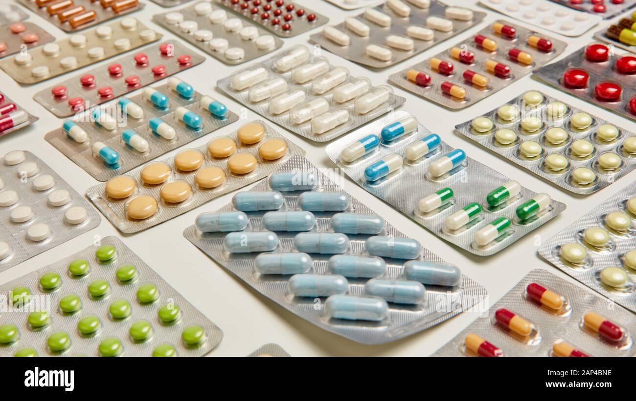 Selection of various colorful tablets and medicines drugs on a table ...
