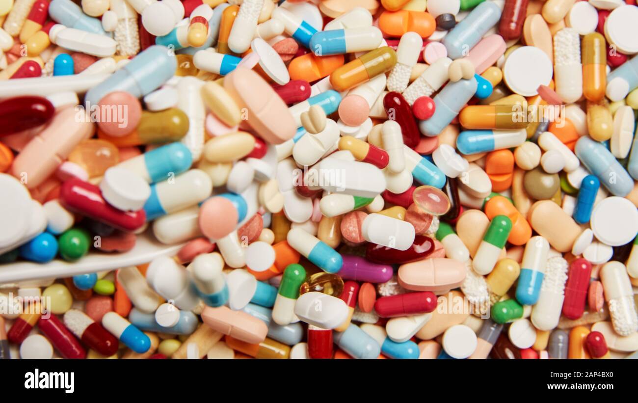 medicines drugs and tablets are tipped onto many colorful medicines ...
