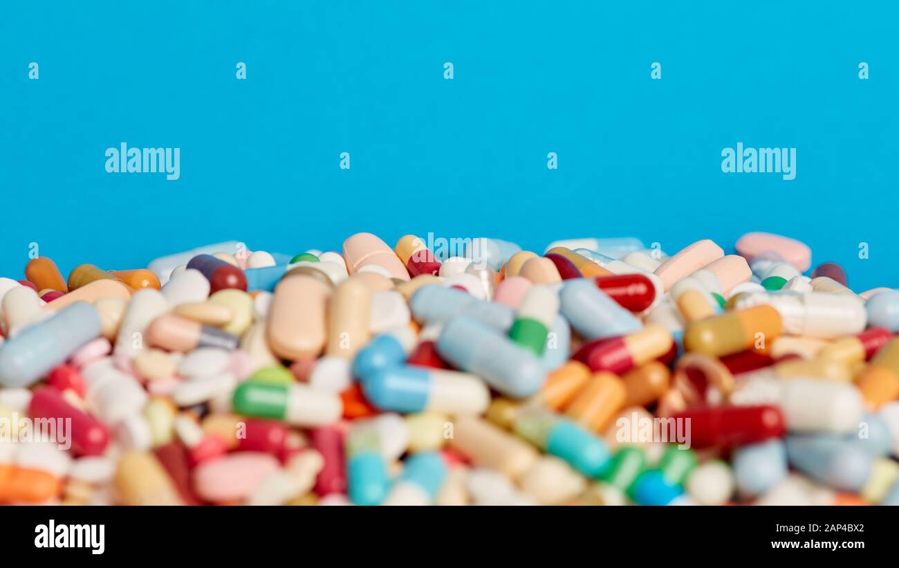 Blue background with lots of colorful medication Stock Photo - Alamy