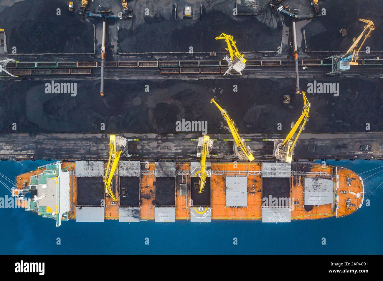 Loading coal anthracite mining in port on cargo tanker ship with crane ...