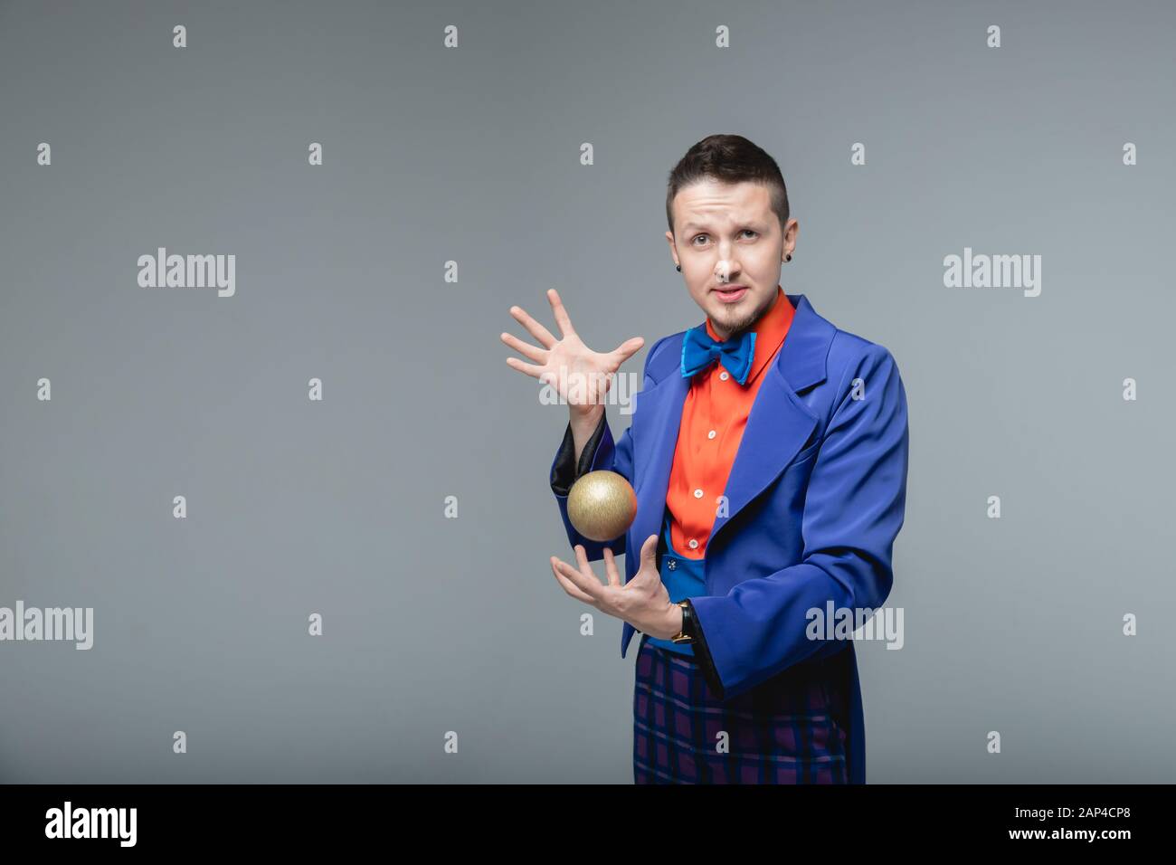 Illusionist magician shows levitation trick with ball in hands on black ...