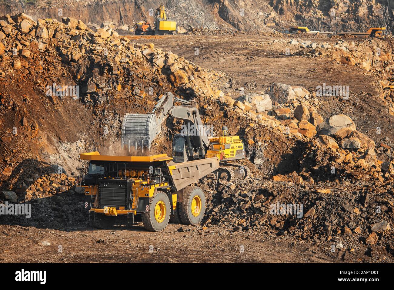 Gold ore mining, loading excavator bucket into body of mine truck Stock ...