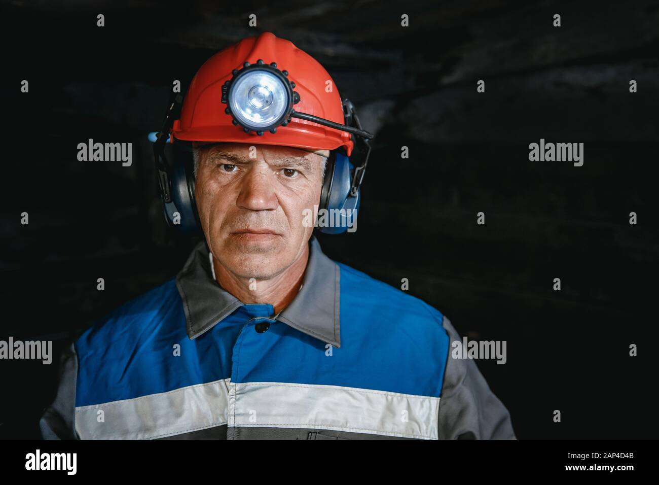 Portrait miner coal man in helmet with lantern in underground mine ...