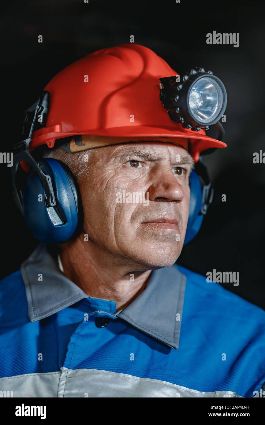 Portrait miner coal man in helmet with lantern in underground mine ...