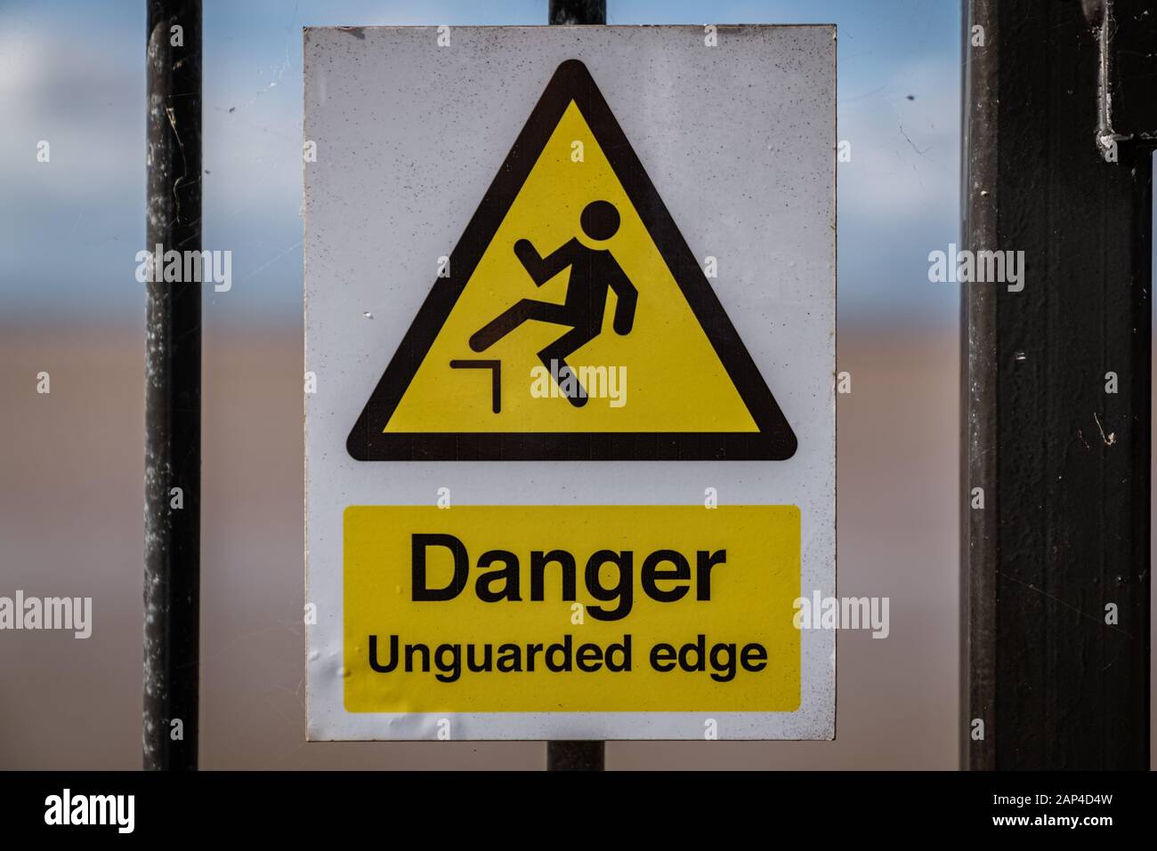 Sign: Danger, Unguarded Edge - with blurry background Stock Photo - Alamy