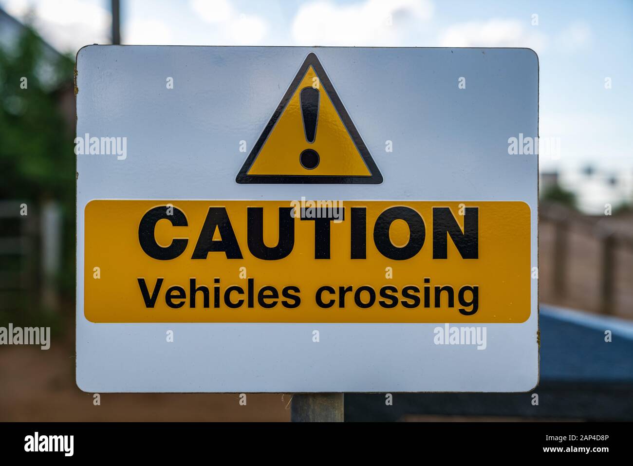 Sign: Caution Vehicles Crossing, with blurry background Stock Photo - Alamy