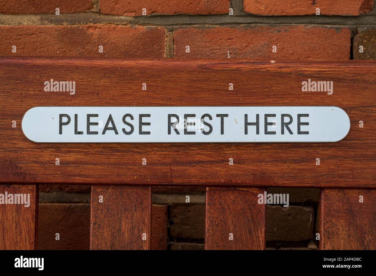 Sign: Please Rest Here - seen on a bench Stock Photo - Alamy