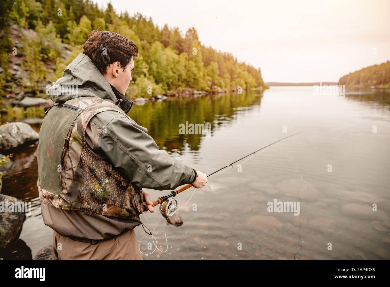Fisherman spool of rope using rod fly fishing in river Stock Photo - Alamy