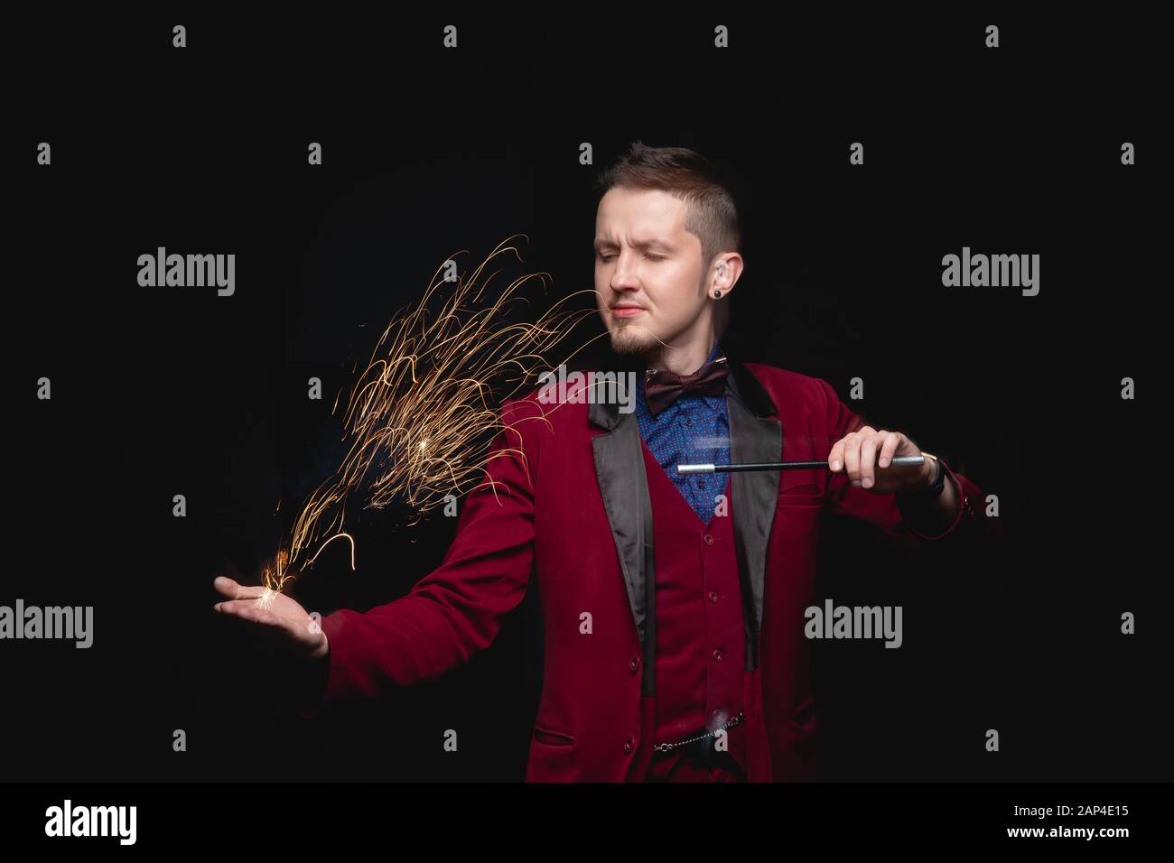 Magician shows focus fire with magic wand and sparks in his hands Stock ...