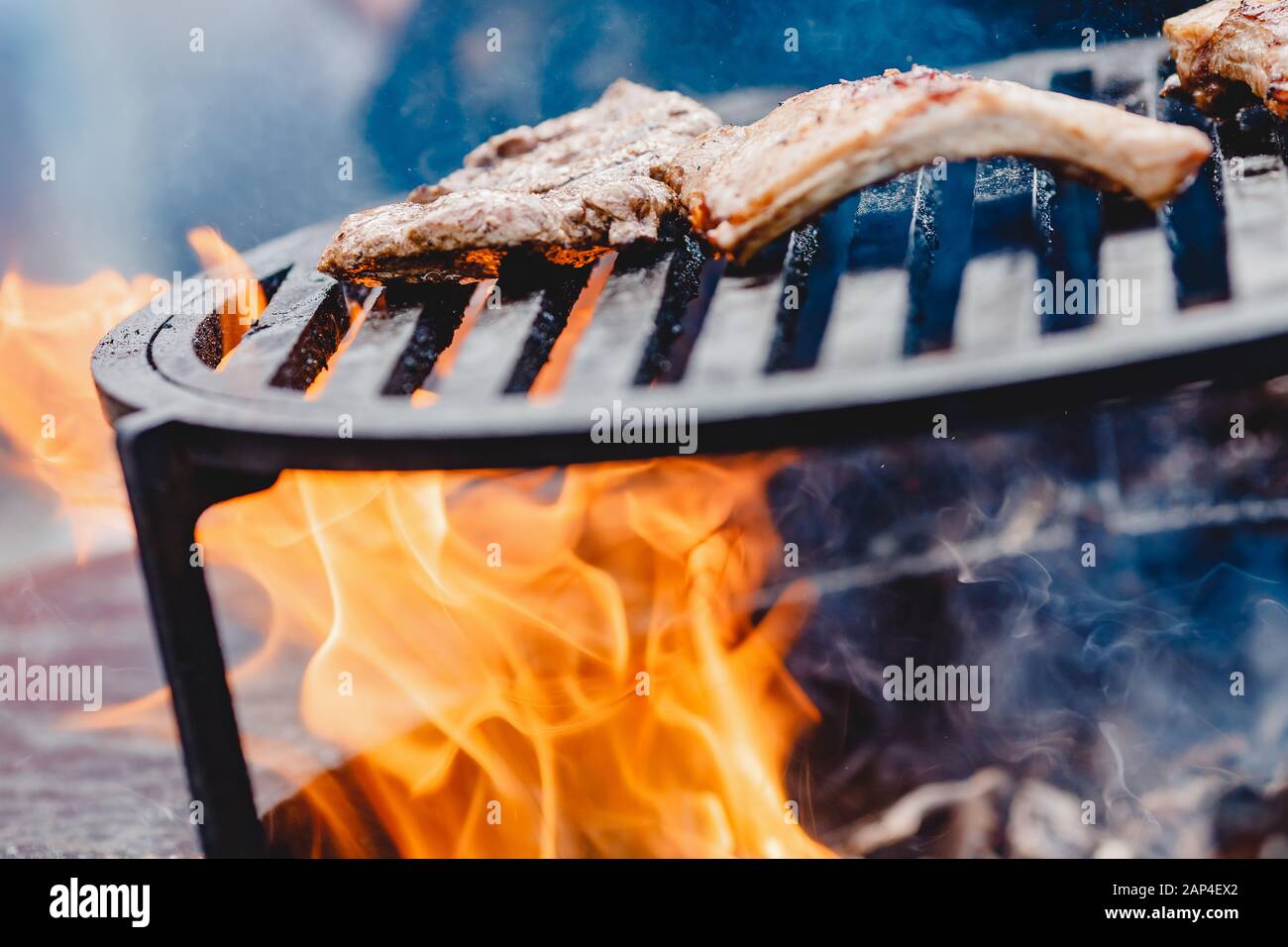 Pork ribs and steak cooked on grill, open fire street food festival ...