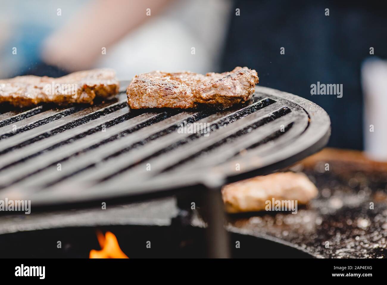 Pork ribs and steak cooked on grill, open fire street food festival ...