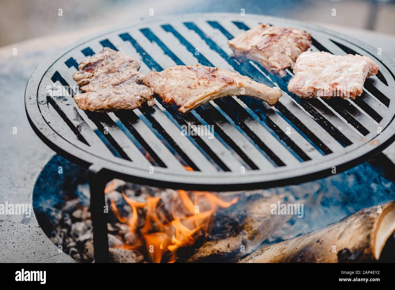 Pork ribs and steak cooked on grill, open fire street food festival ...