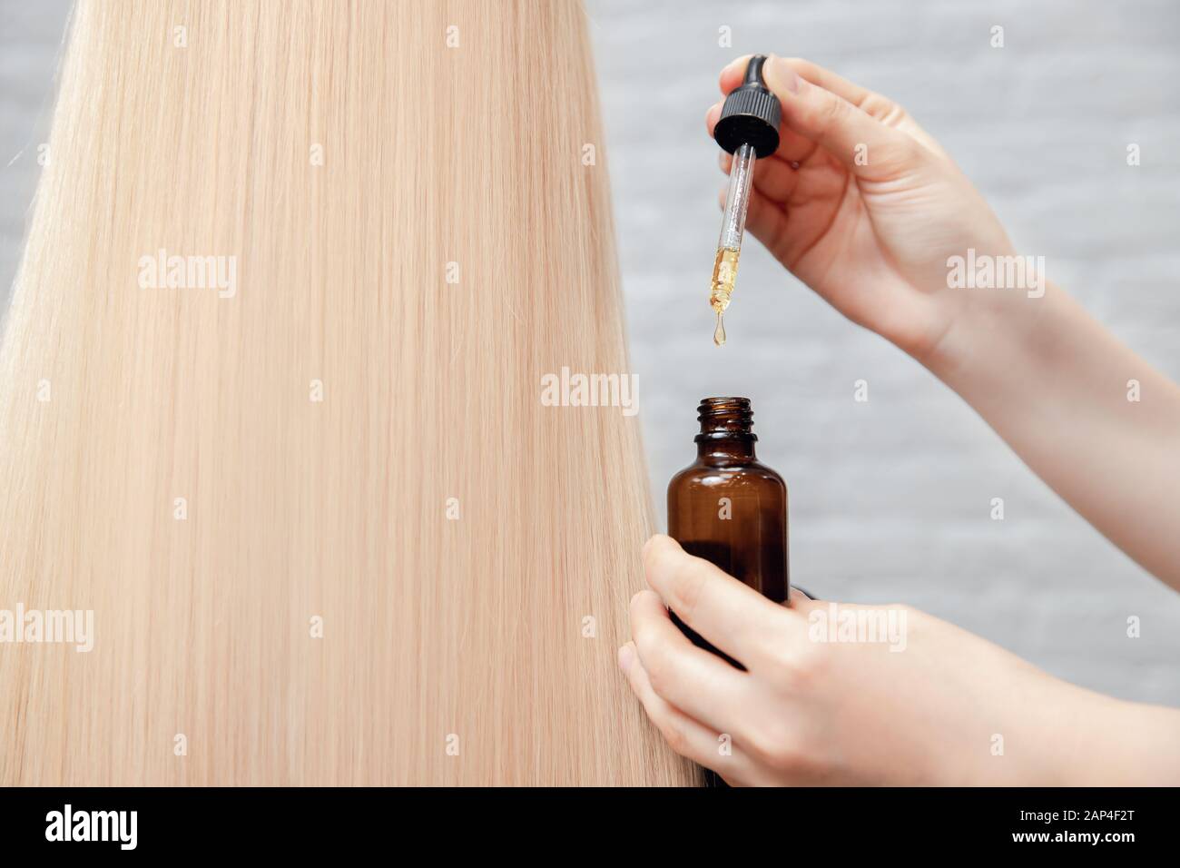 Close-up drop of oil restore and recovery hair is applied to head bulbs ...