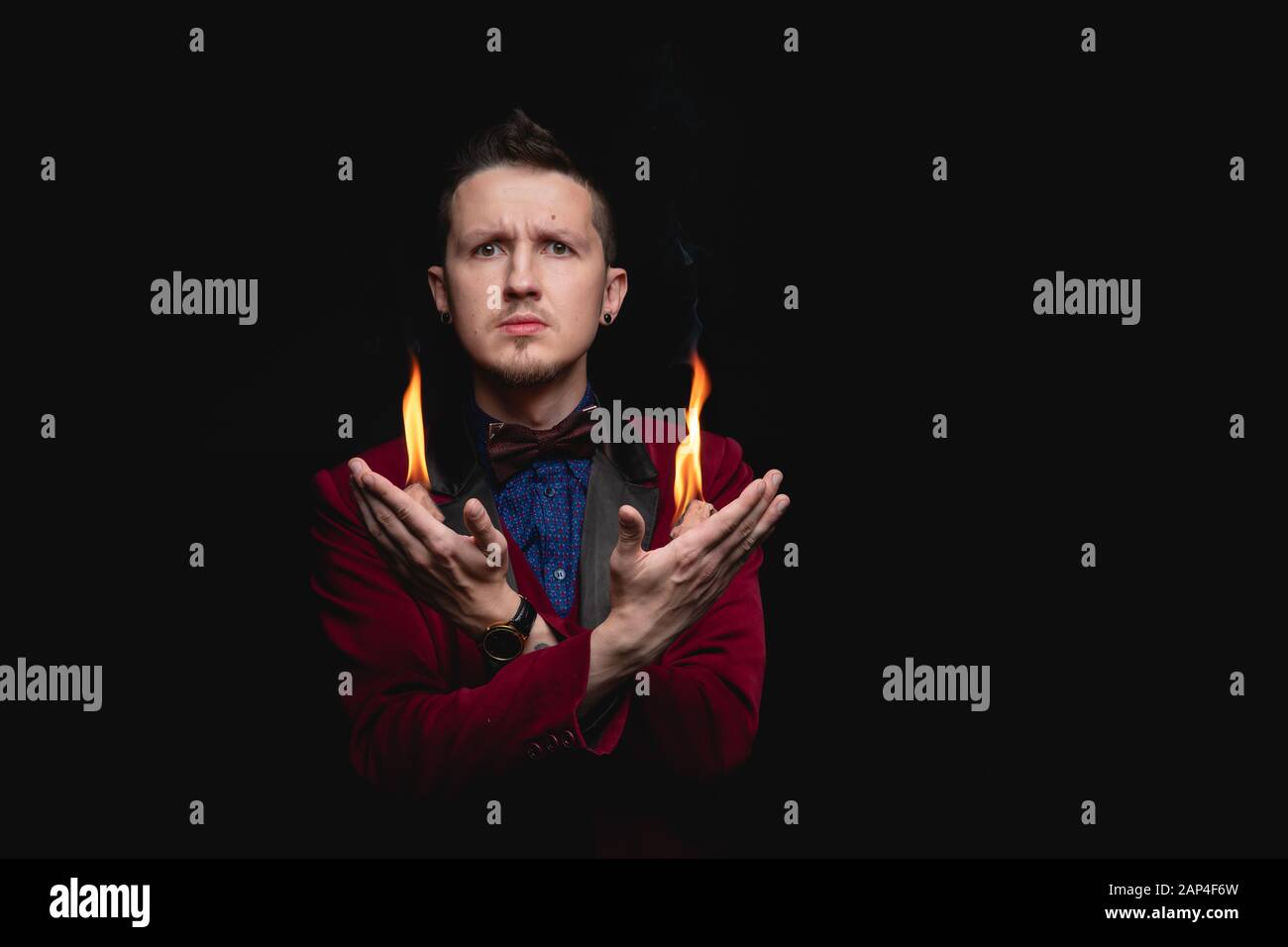 Focus with fire from palms hands shows magician on black background ...