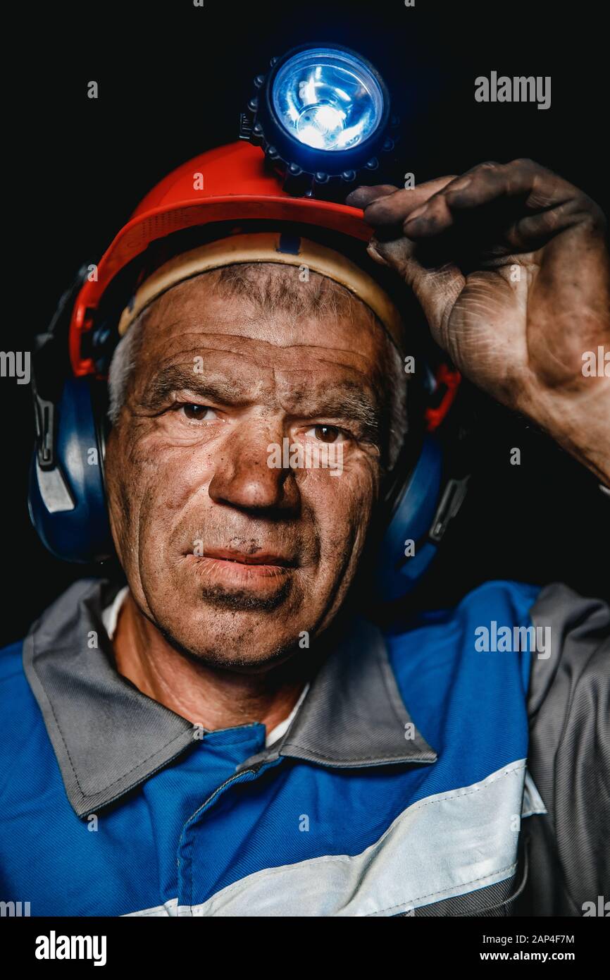 Portrait miner coal man in helmet with lantern in underground mine ...