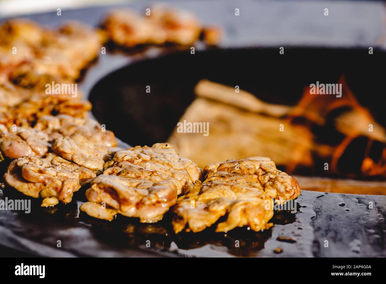 Pork ribs and steak cooked on grill, open fire street food festival ...