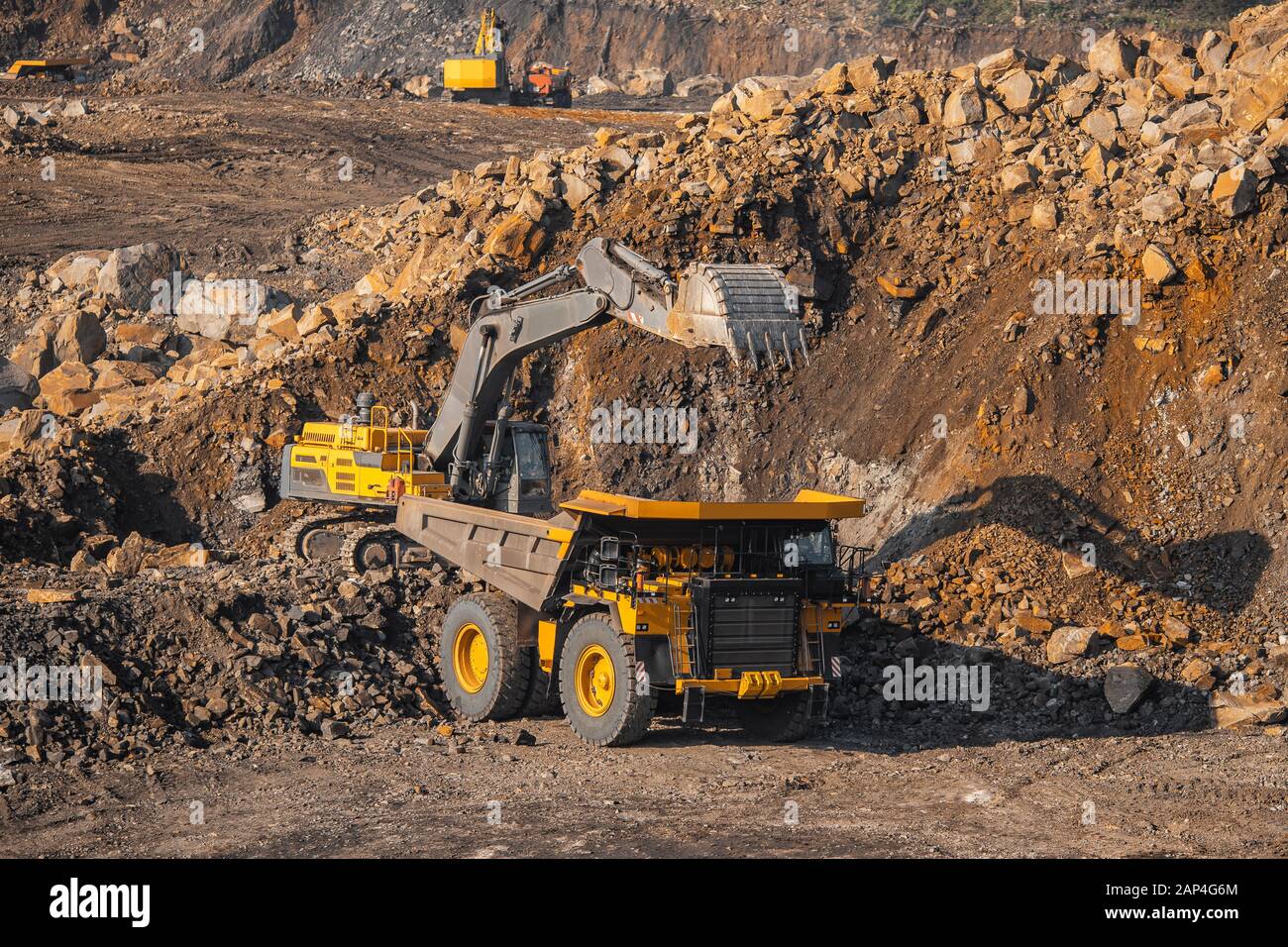 Open pit mine industry, excavator loading coal on big yellow mining ...