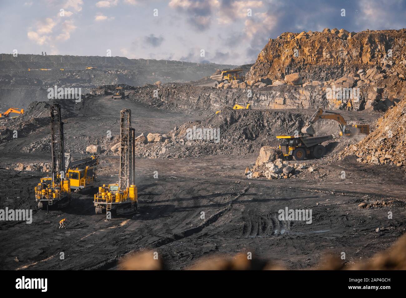 Open coal mine. Drilling machine borer installing cast explosives ...