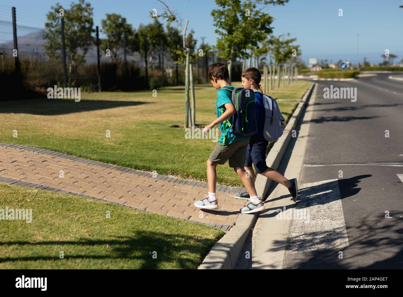 Two schoolboys reaching the pavement after crossing the road Stock ...
