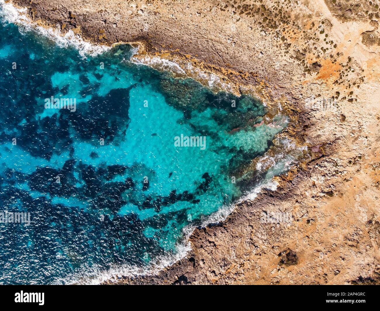 Top view Azure blue sea with waves beating on beach and rocks. Aerial ...