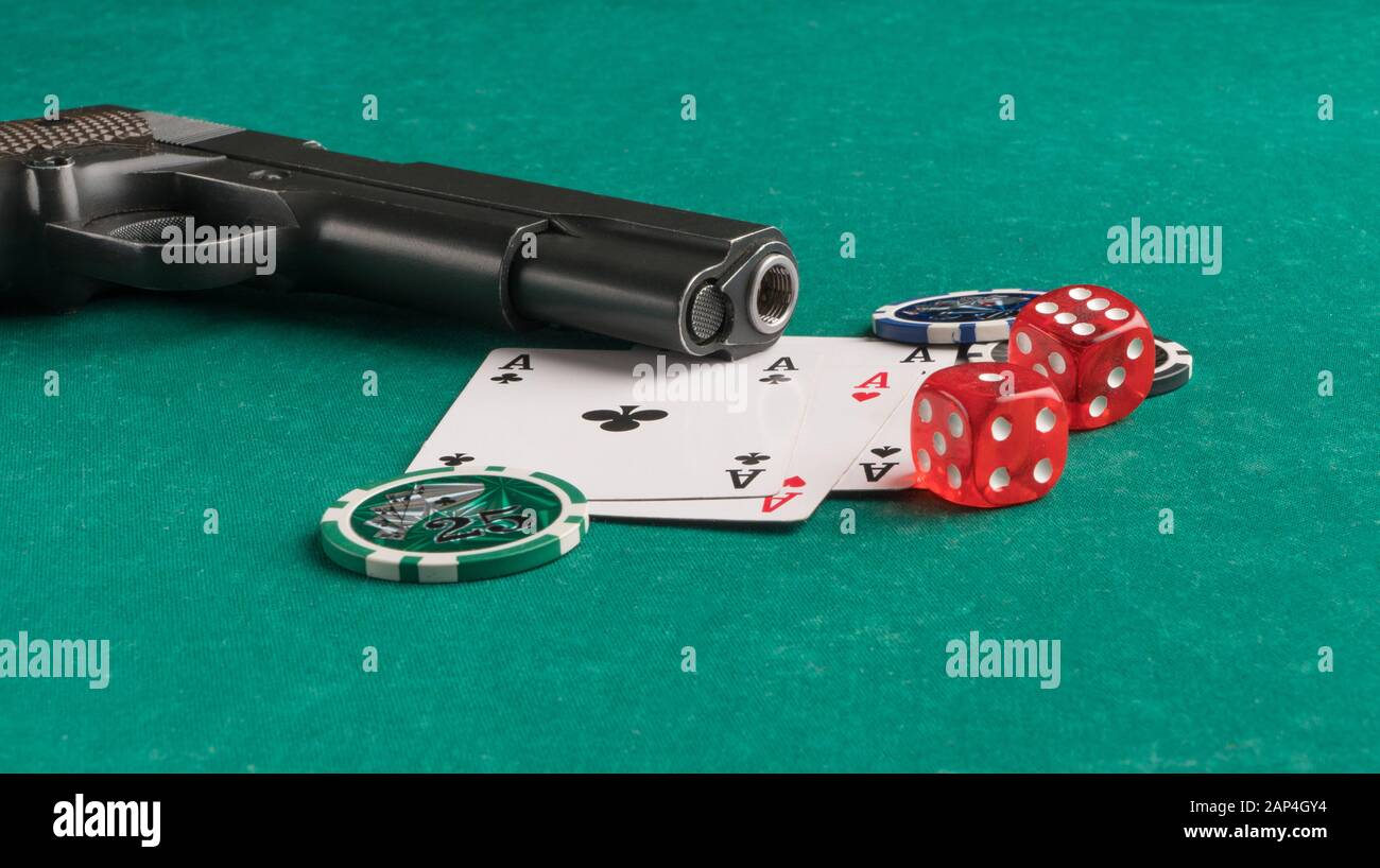 Poker chips, cards and gun on a green background. The concept of ...