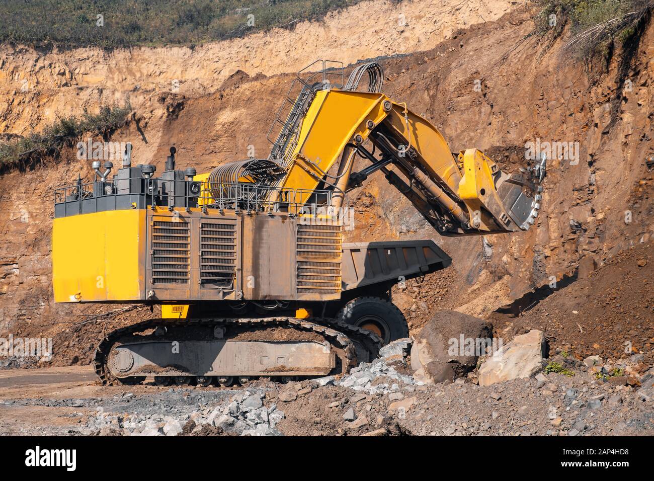 Loader excavator during earthmoving works loads soil ground into large ...