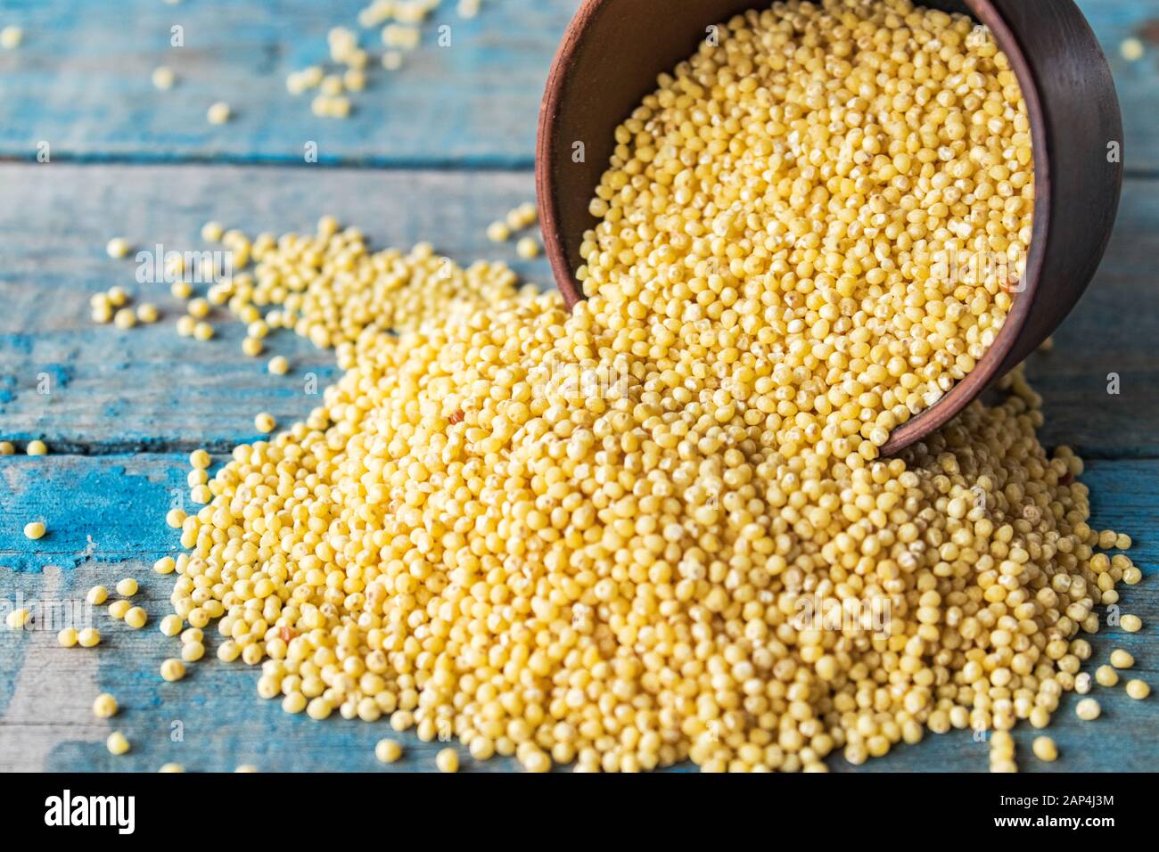 A pile of dry yellow millet lies on old blue boards. Close-up Stock ...
