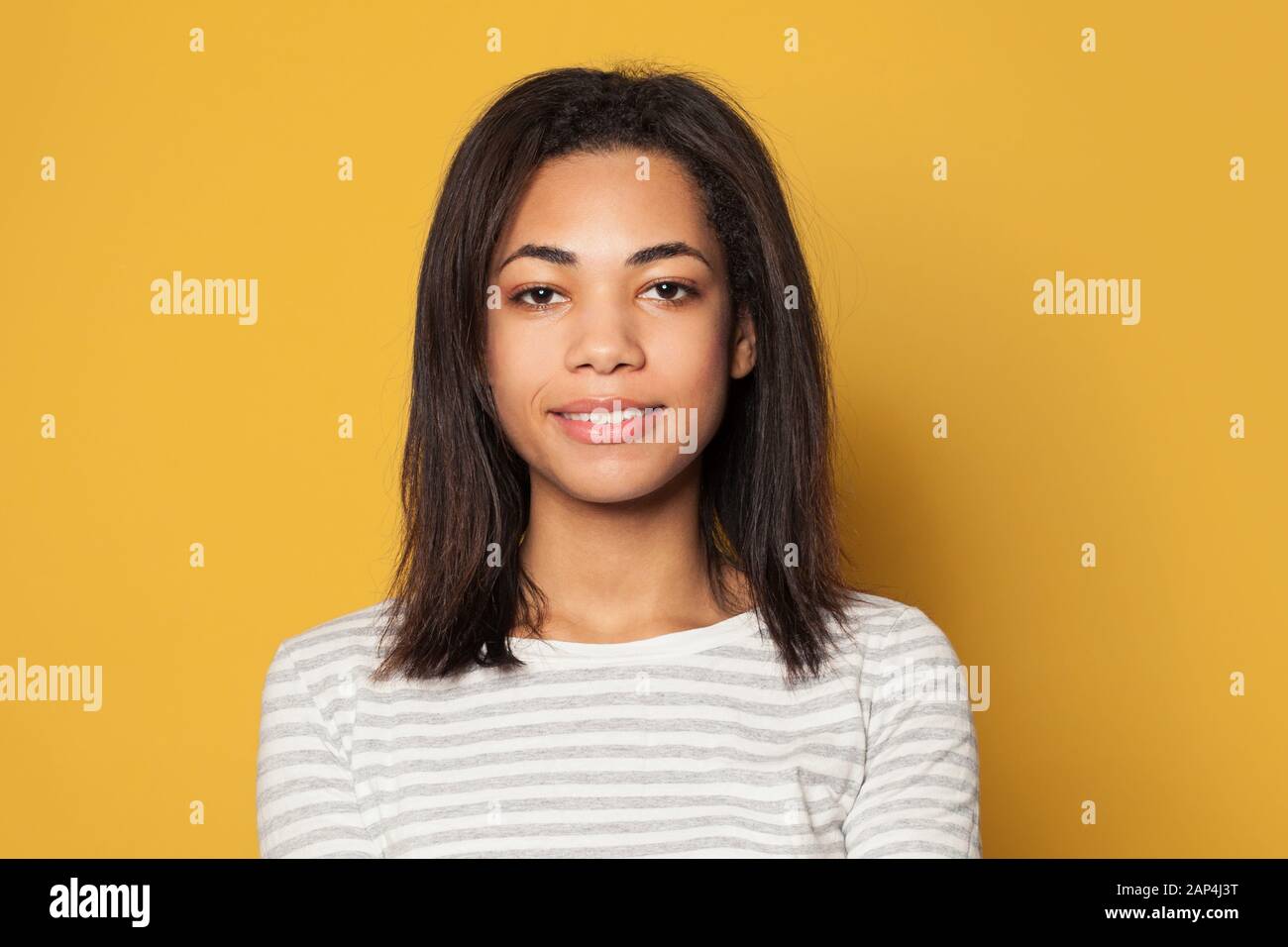 Pretty smiling girl on yellow background portrait Stock Photo - Alamy