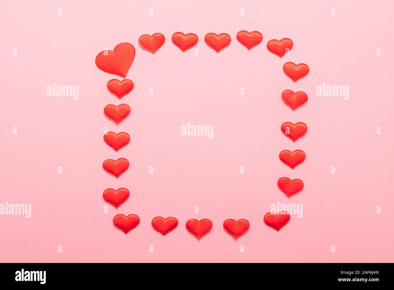 Red hearts symbol of love lined with a square frame on a pink ...