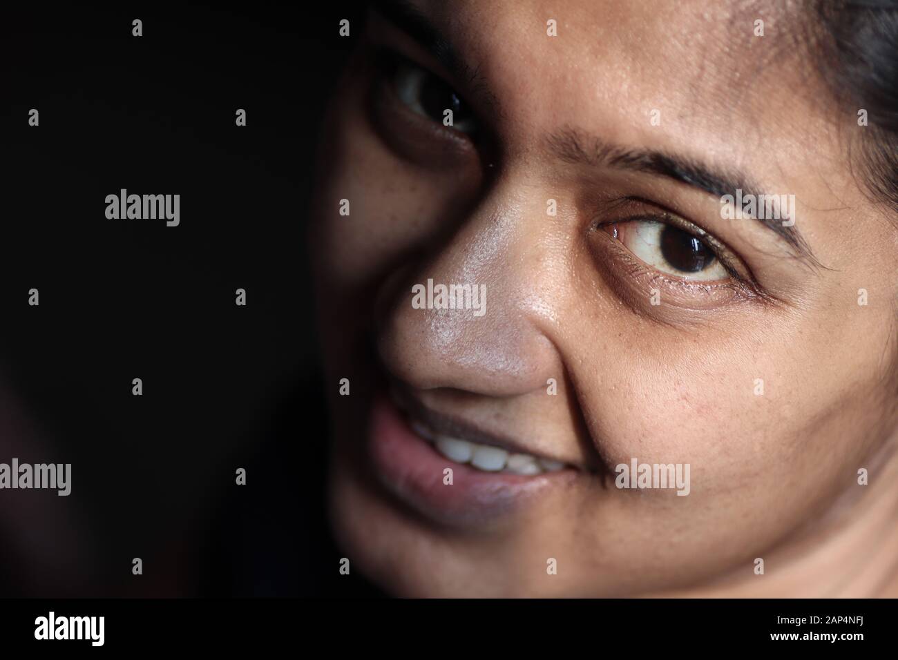 closeup portrait of a lady with light on half of her face with ...