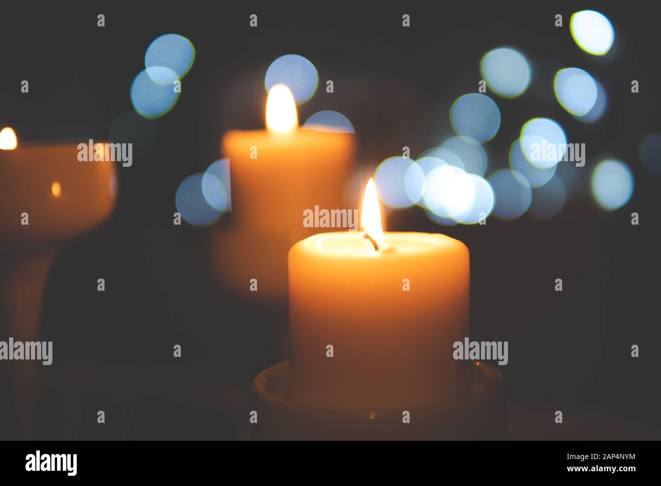 A warm yellow candle quietly burning in the dark. Beautiful fire of a ...