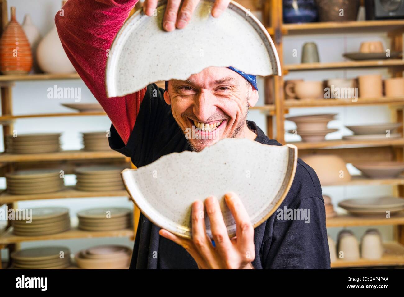 Crazy potter master smiling through the broken ceramic hand made plates ...