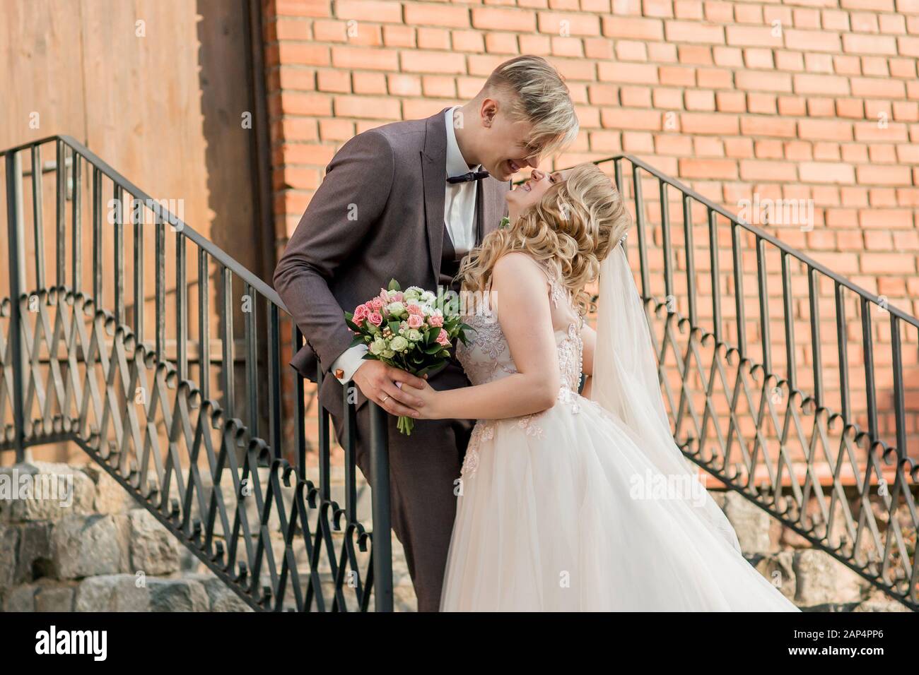bride and groom standing on the porch of a brick house Stock Photo - Alamy