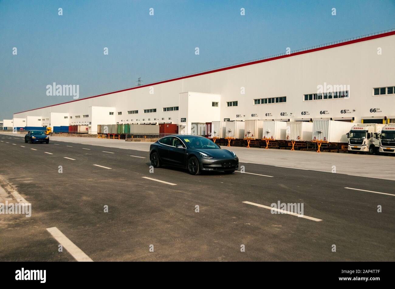 A row of Chinese made Tesla Model 3s driving past the new Tesla factory ...