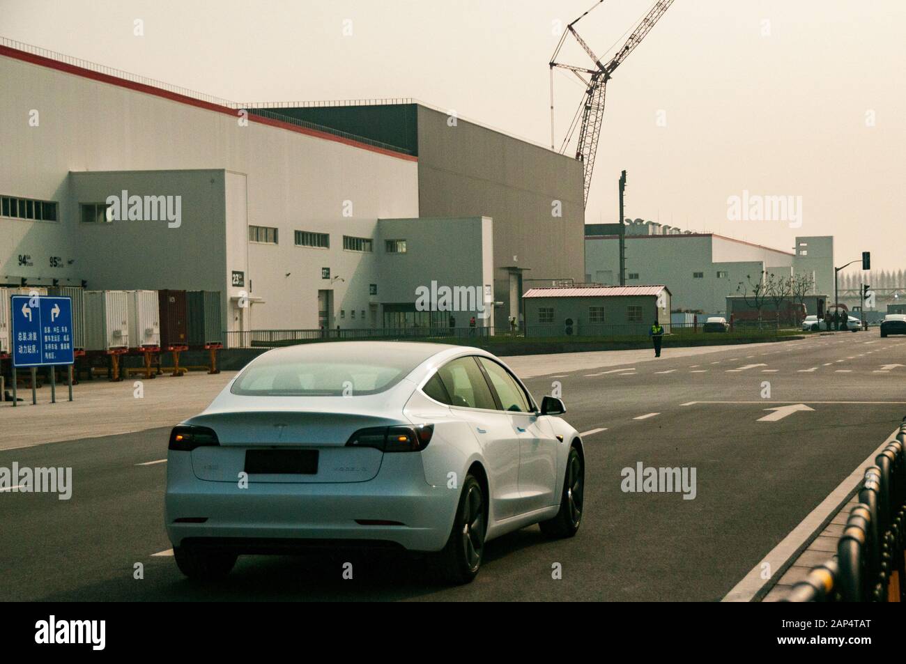 A Chinese made Tesla Model 3 driving past the new Tesla factory in ...