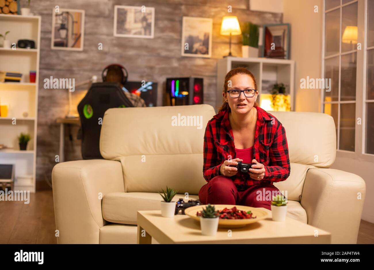 Woman gamer playing video games on the console in the living room late ...