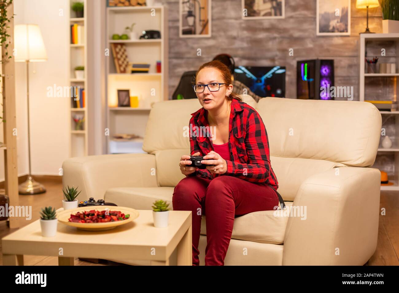 Woman gamer playing video games on the console in the living room late ...