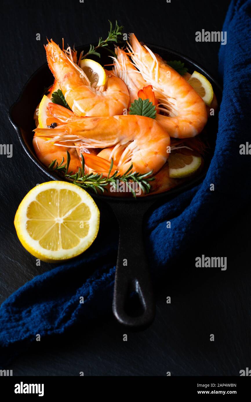 Seafood concept Ocean king prawns cooked in skillet iron cast on black ...