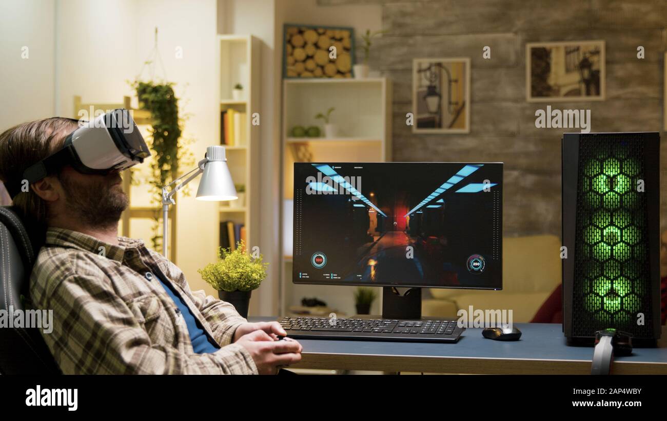 Man sitting on gaming chair playing video games using vr headset with ...