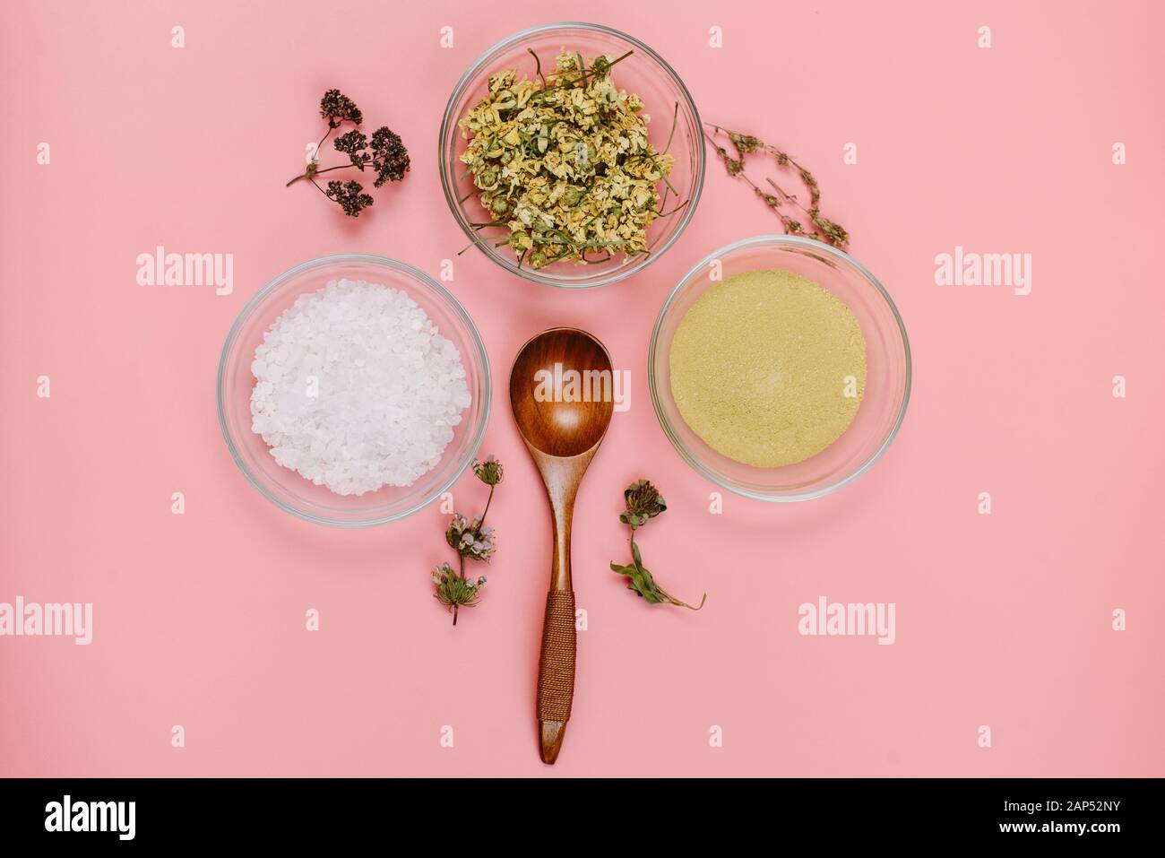 Collagen powder or yellow clay with dried flowers and sea salt on pink ...
