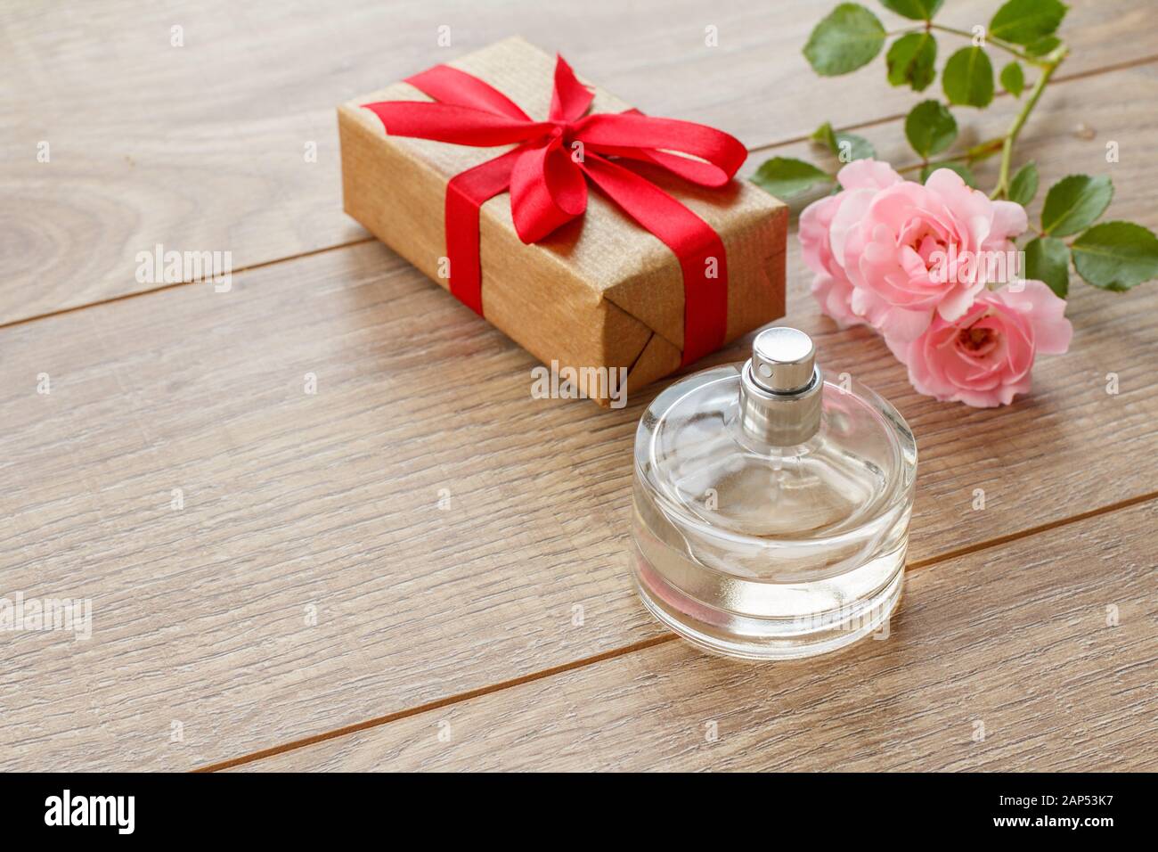 Gift box with perfume on wooden boards decorated with pink rose flowers ...