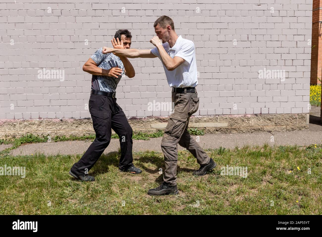 Mature male instructor shows a technique of dodging a direct punch ...