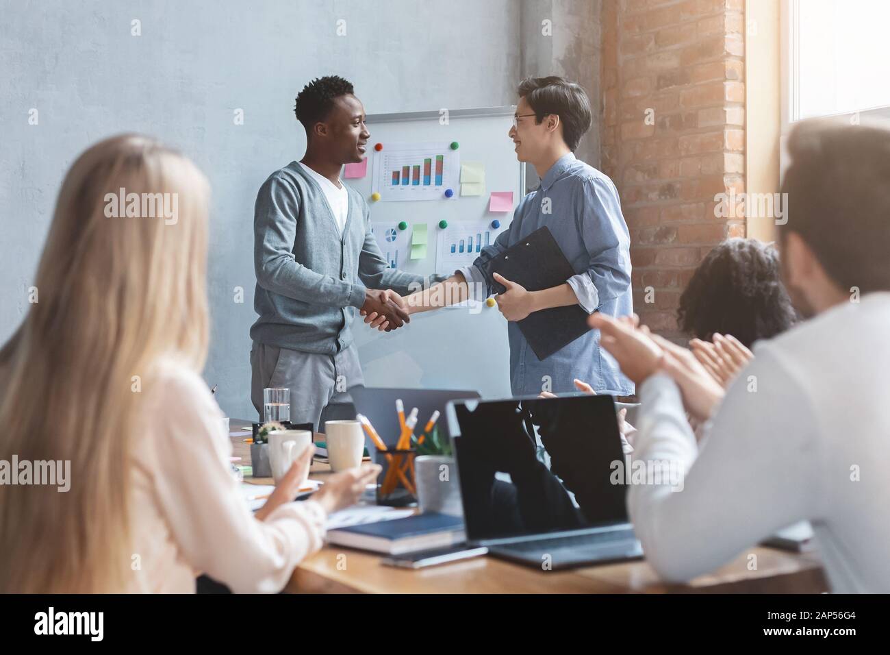 Young black manager shaking hand to asian employee Stock Photo - Alamy