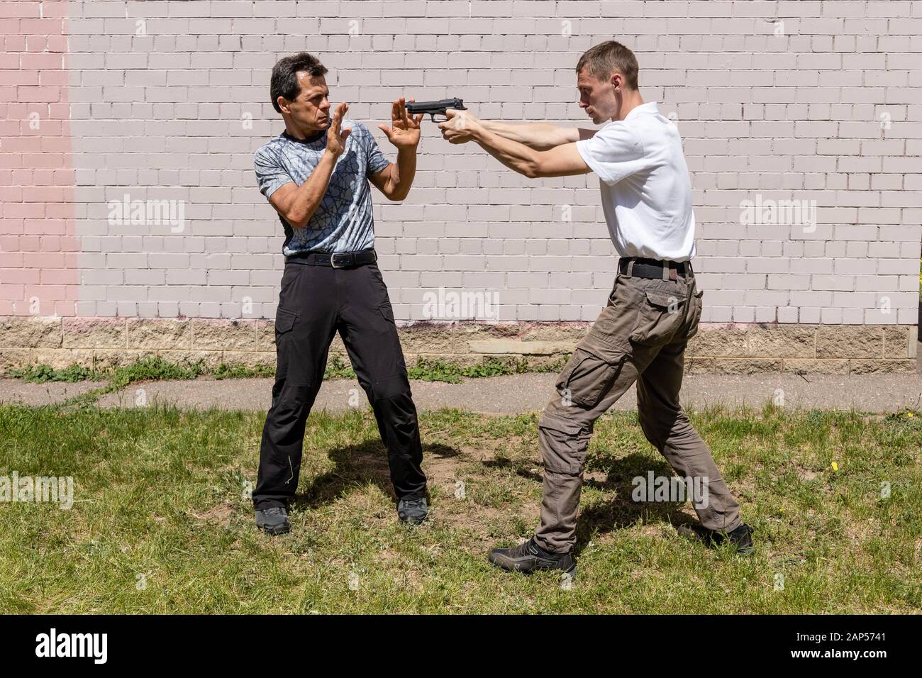 Young man threatens arms to mature man. Self Defense Techniques Krav ...
