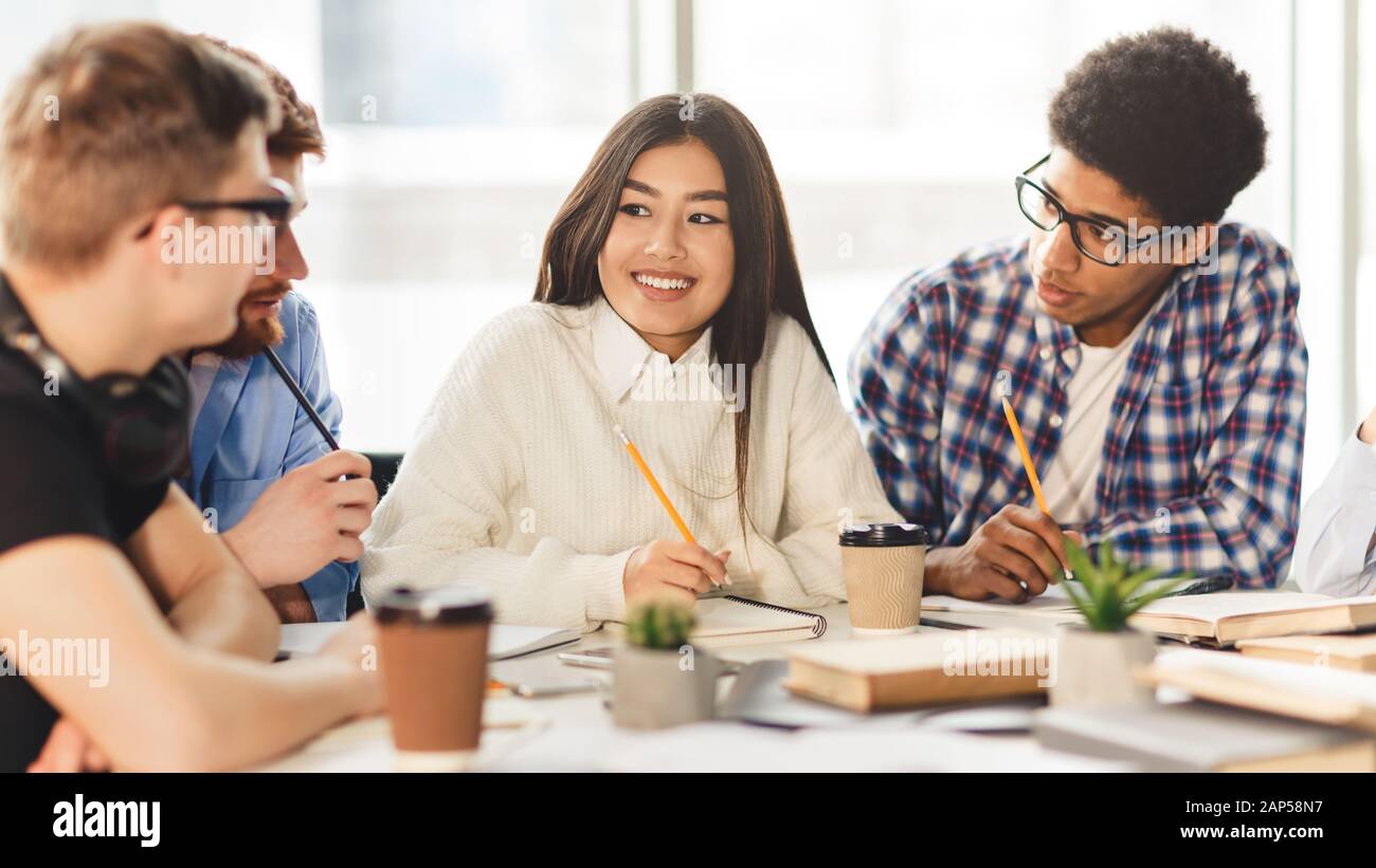 Happy multiracial college students studying with books in library Stock ...