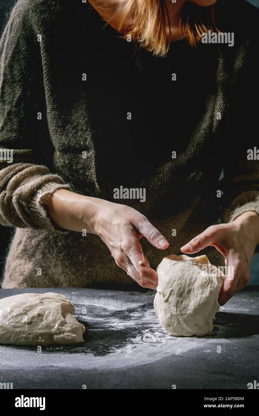 Process of making homemade bread dough. Female hands splits dough on ...