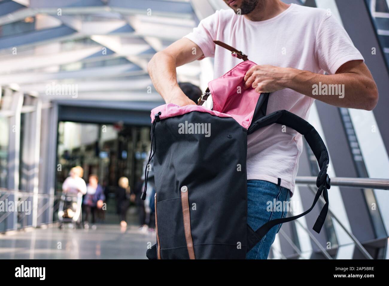 Young man tourist standing, searching and getting something out of his ...