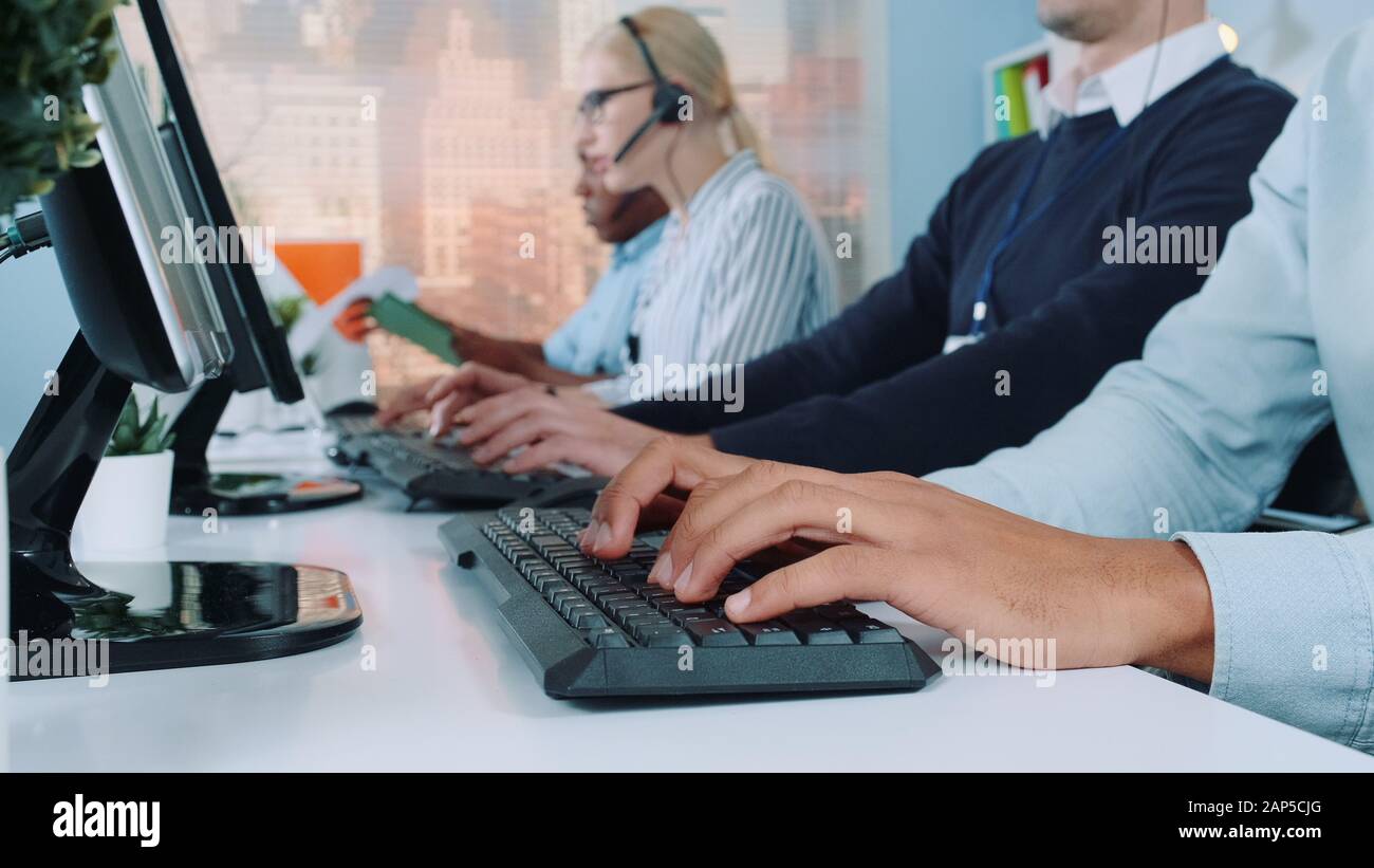 Medium shot of operators hands typing on keyboard in modern office ...
